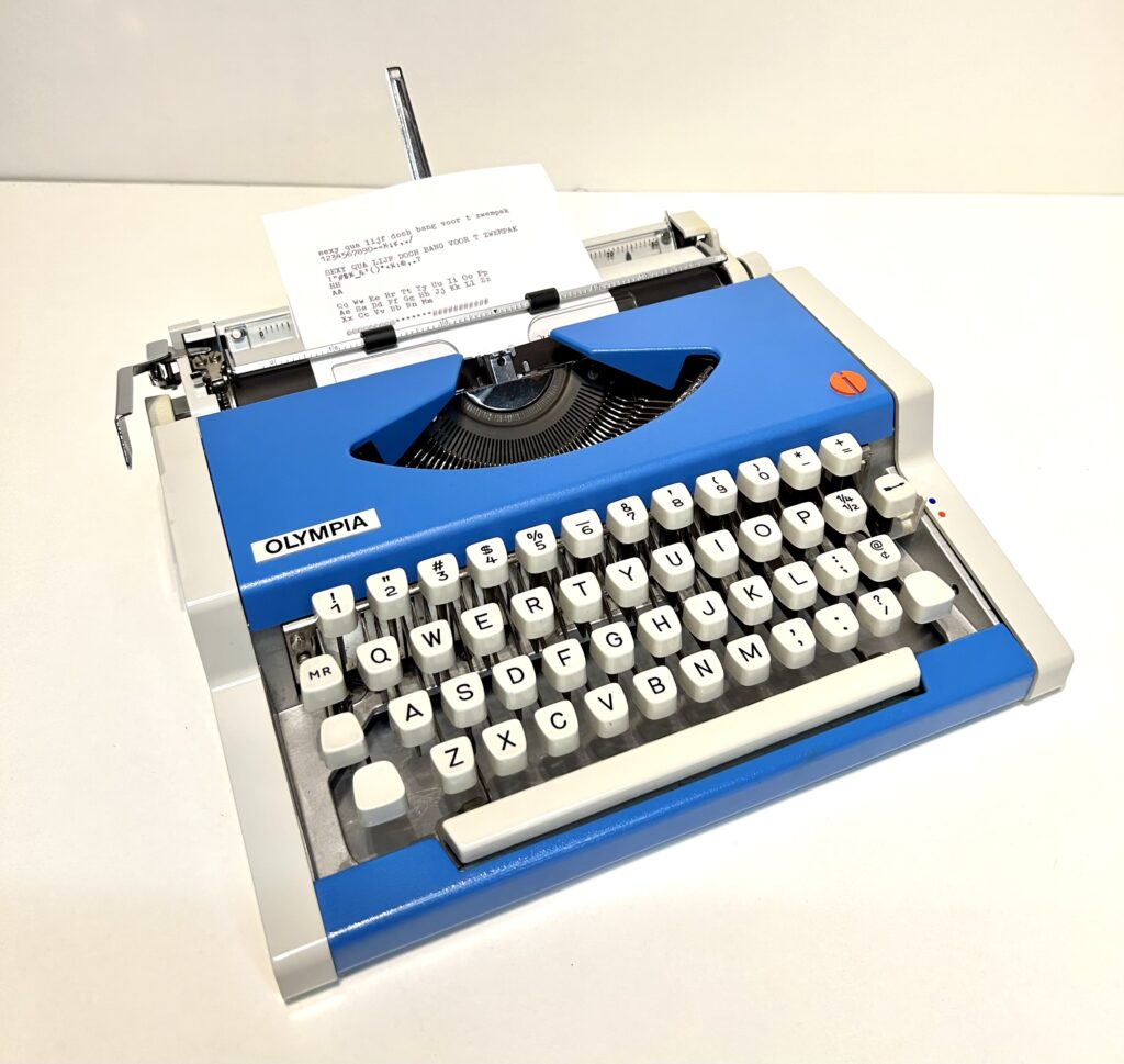 Blauwe Olympia traveler vintage werkende typemachine witte toetsen en ...